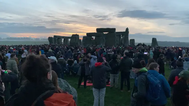 Thousands welcome winter solstice as Sun rises over Stonehenge - BBC News
