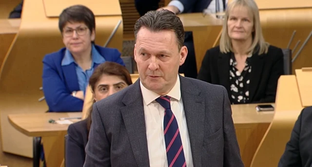 Swinney accused of 'miserly' tax cuts in the budget at FMQs - BBC News