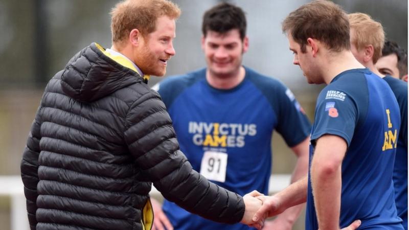 Prince Harry helps athlete after wheelchair blows over - BBC News