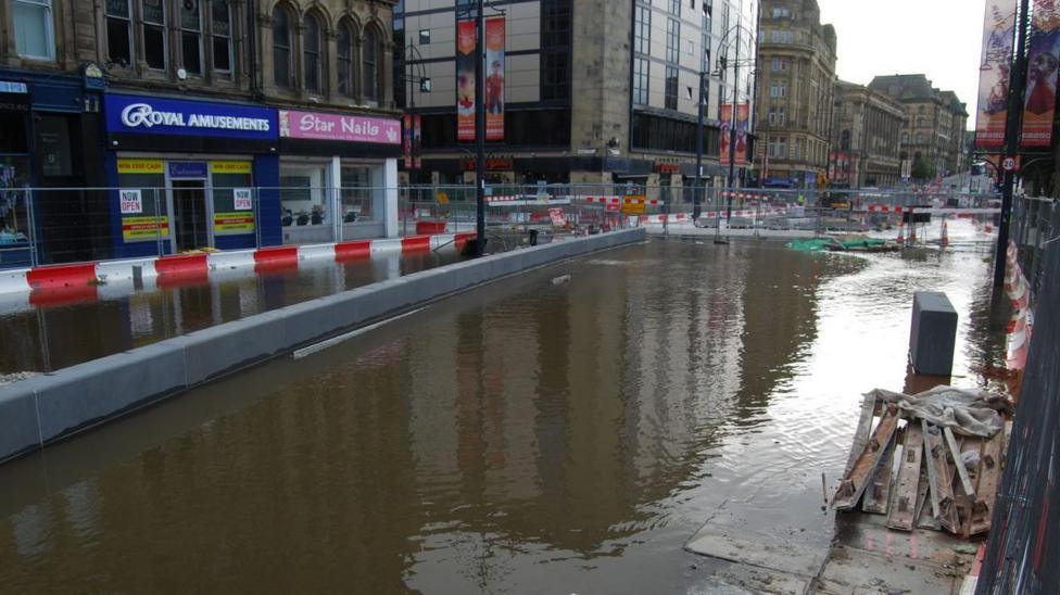 Investigation after burst main floods street - BBC News