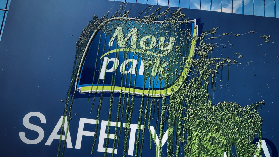 Lough Neagh algae: Activists hold 'vomiting' protest at Moy Park - BBC News