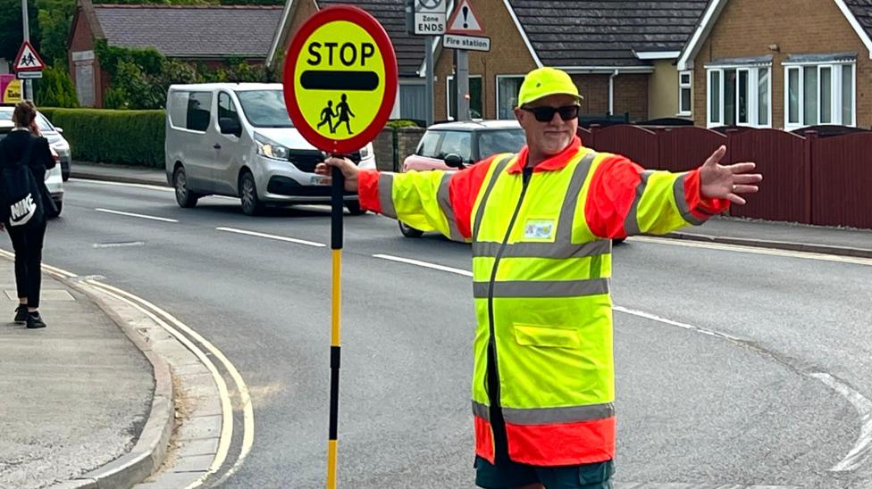 Howden lollipop man told to stop giving kids high-fives - BBC News