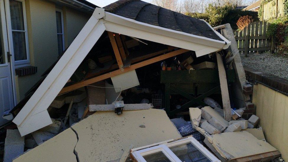 Wadebridge pair trapped in car as garage collapses - BBC News