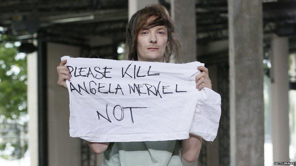 Model holding 'kill Merkel' protest sign 'punched' at fashion show ...