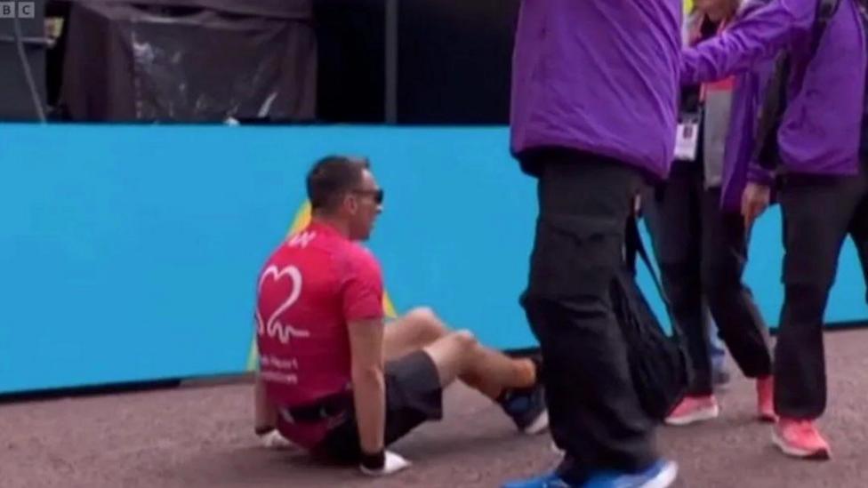 Exeter teacher's 'bum shuffle' marathon finish inspires students - BBC News