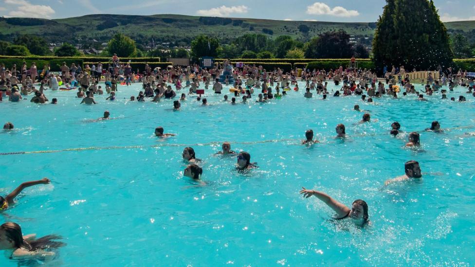 Hundreds brave the cold for full moon Ilkley Lido swim - BBC News