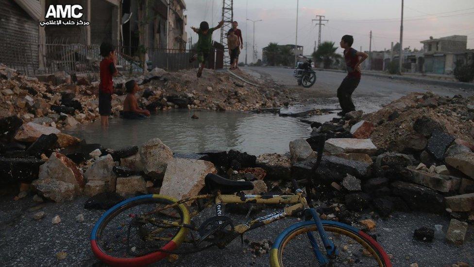 Syrian boys swim in crater as battle for Aleppo rages - BBC News