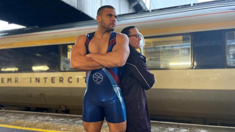 Gladiators Giant and Steel help passengers at Sheffield station - BBC News