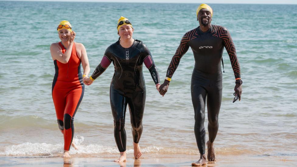 Bournemouth: More than 1,200 take to sea for charity swim - BBC News