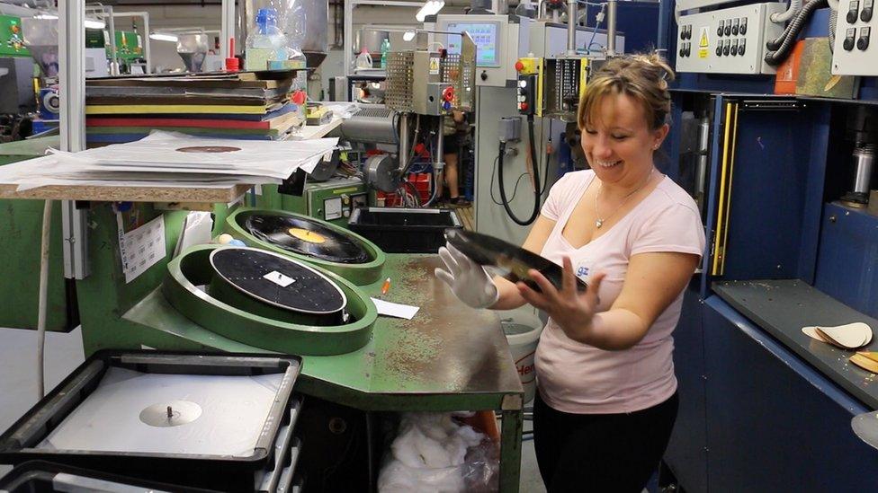 A worker inspects a vinyl record at a factory in the Czech Republic