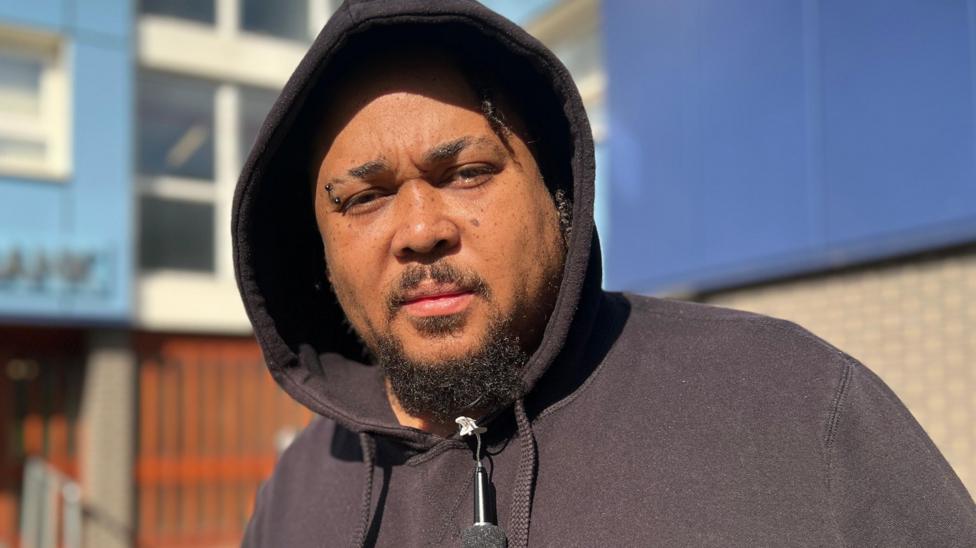 Tributes left as teen held over Luton tower block deaths - BBC News