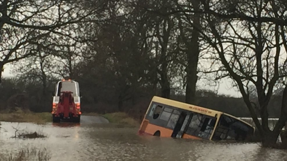 School children trapped in bus by flood water near York - BBC News