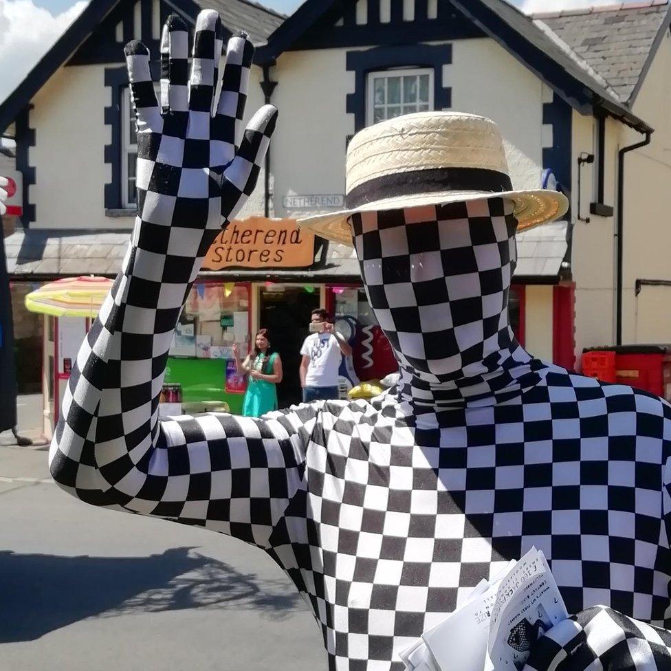 Mystery carnival mime artist gives cash to vicar - BBC News