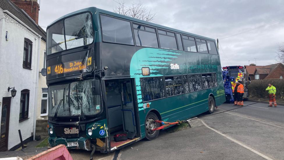 Driver in hospital after bus crashes into house in Underwood - BBC News