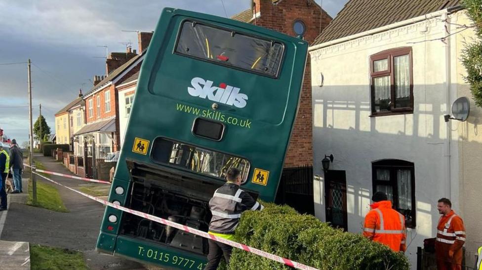 Driver in hospital after bus crashes into house in Underwood - BBC News