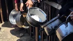 खाना पकाउने भाडाँ बोकेर बारमा उभिइरहेकाहरू