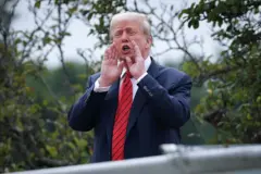 Donald trump faz gesto com as mãos perto da boca
