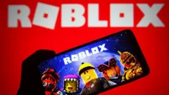 Dalam ilustrasi foto ini, logo Roblox dari platform game online terlihat di ponsel pintar dan layar komputer. 