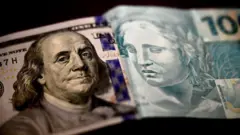 Montagem mostra face de nota de dólar americano à esquerda e a de nota de real brasileiro à direita 