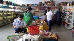 डिपार्टमेन्टल स्टोरमा बेच्न राखिएका खाद्य सामग्री निरीक्षण गर्दै सरकारी कर्मचारीहरू