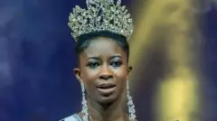 La Miss Côte d'Ivoire 2025 porte sa couronne et tient entre ses mains un bouquet de fleurs