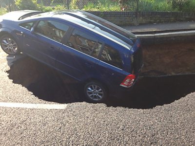 Parked car falls down huge hole in south-east London - BBC News