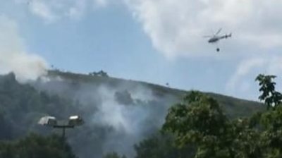 Helicopter drops water on Graig Mountain fire - BBC News