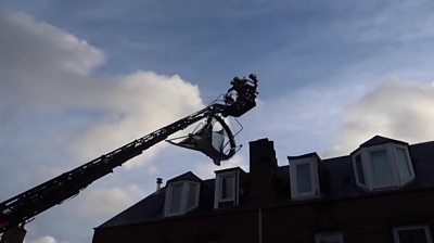 Firefighters rescue a trampoline from the roof of a house - BBC News