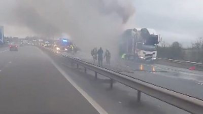 Truck loaded with cars catches fire on M74 - BBC News