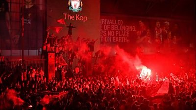 Liverpool fans celebrate outside Anfield Stadium with flares and ...