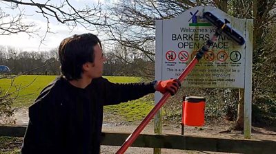 Norfolk window cleaner washes road signs to help community - BBC News