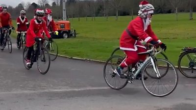 Dozens of cyclists dress as Santa for a Christmas ride - BBC News