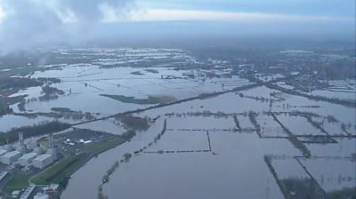 Watch: Drone footage shows hamlet cut off by floods - BBC News