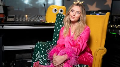 Perrie Edwards dons vibrant pink pyjamas with feather trim to read a ...