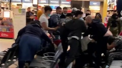 Eleven charged after fight breaks out at Luton Airport - BBC News