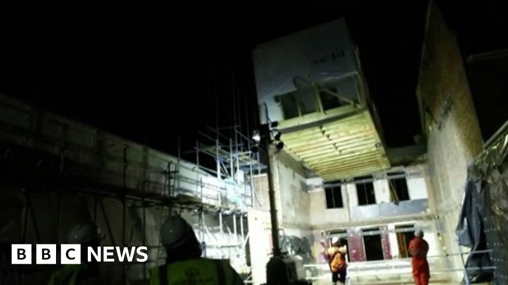 Engineers lower pre-built flat into Bristol building