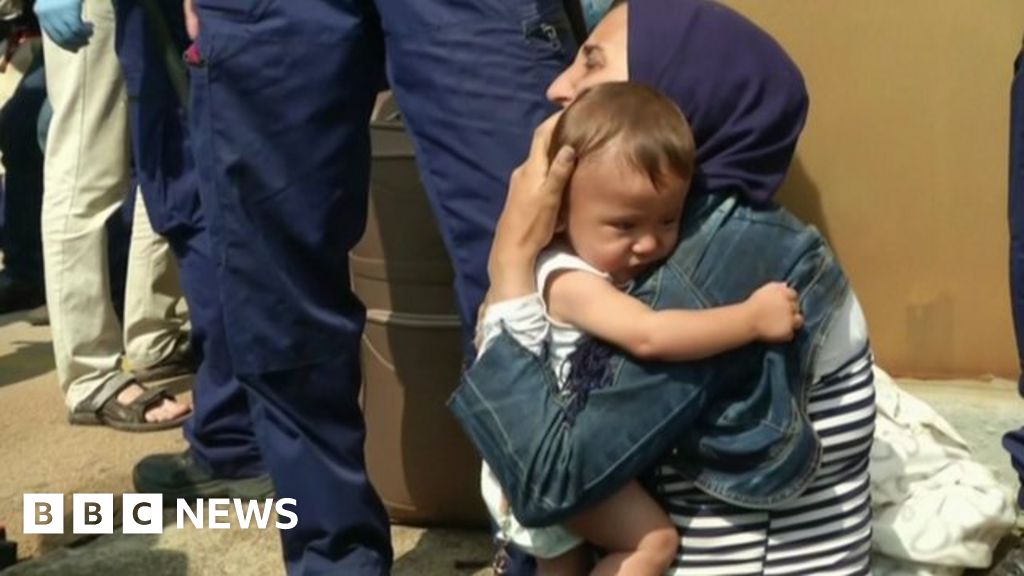 Riot police force mother and baby off train track in Hungary - BBC News