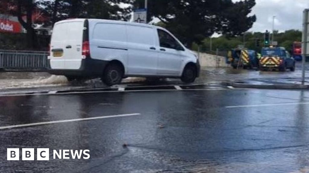 Burst water main in Poole floods main road - BBC News