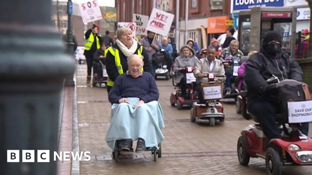 Luton mass mobility scooters in protest drive at funding cuts - BBC News