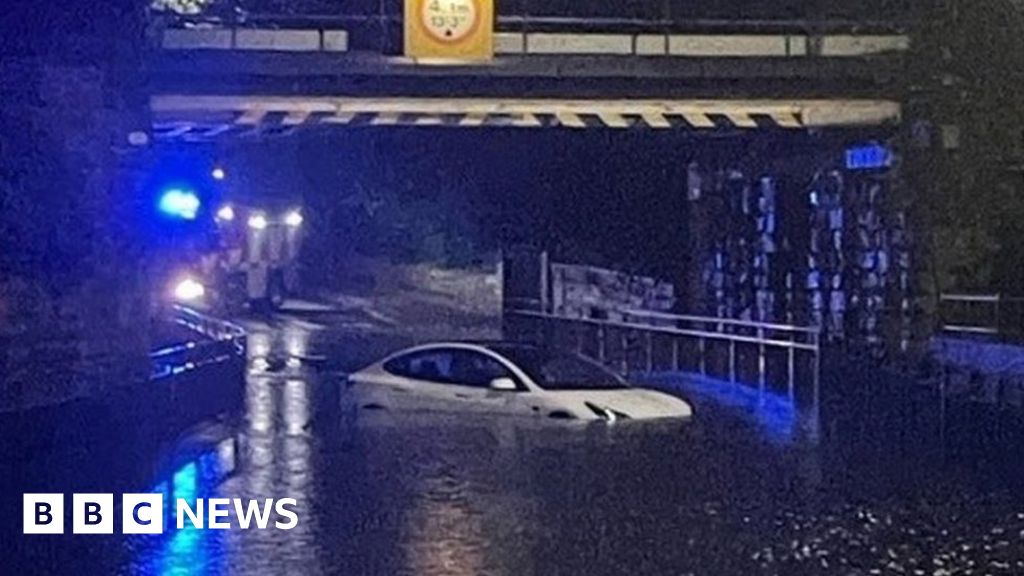 Ashby de la Zouch: Car half-submerged in floodwater under bridge - BBC News