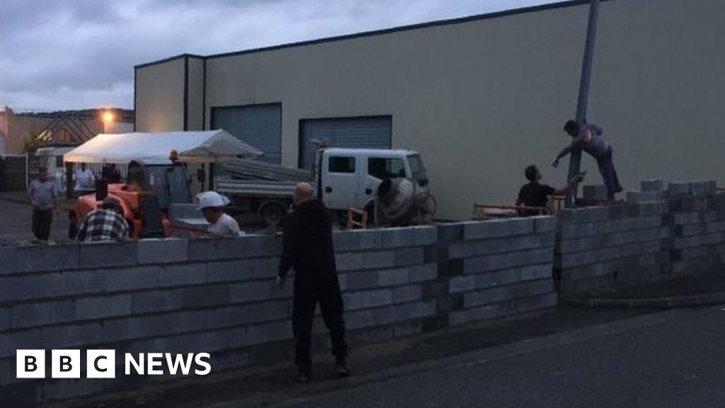 France migrants: Protesters build wall around shelter