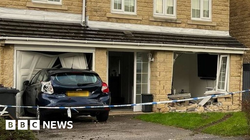 Bradford home damaged as car smashes through lounge wall - BBC News