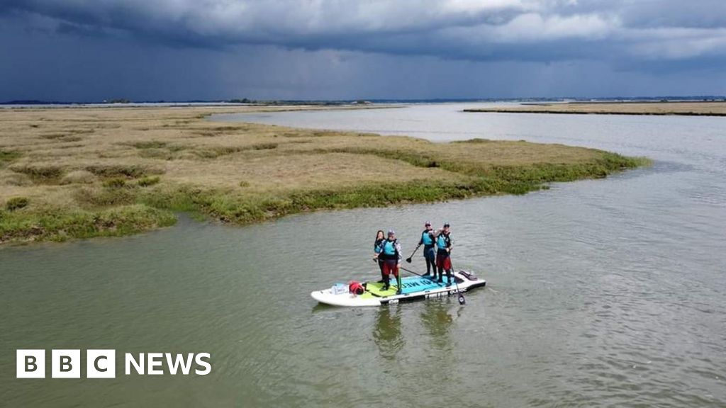 Friends paddle around Mersea Island on giant SUP for RNLI - BBC News