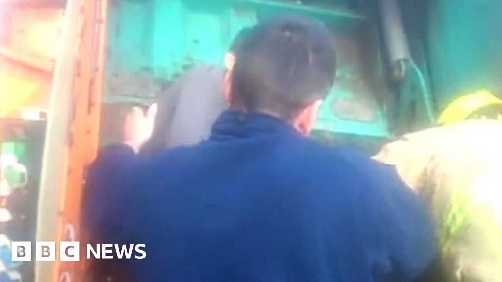 Sleeping man rescued from Workington recycling wagon - BBC News