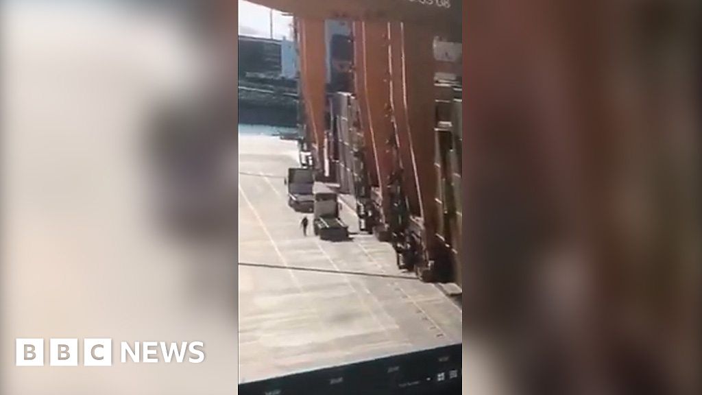Dock worker escapes plummeting shipping containers - BBC News
