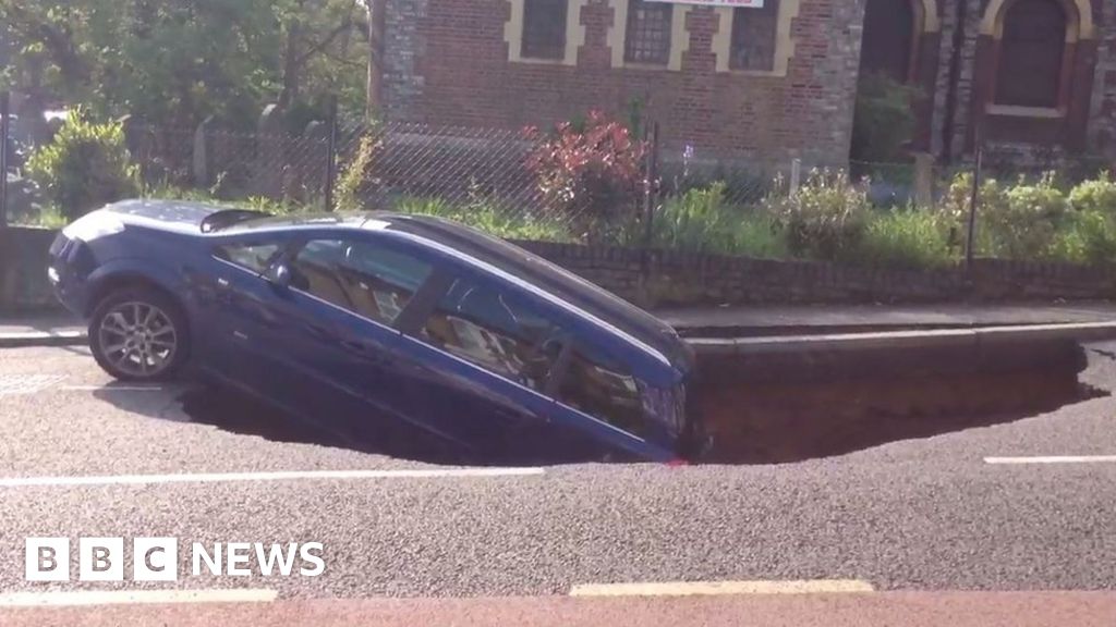 Parked car falls down huge hole in south-east London - BBC News