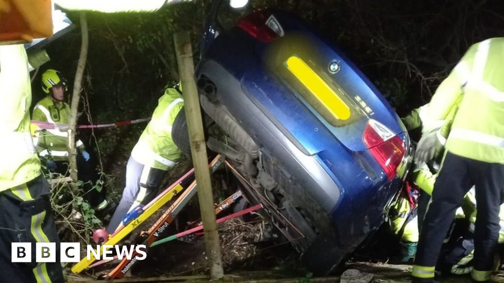 Driver cut free from car after crash into garden - BBC News