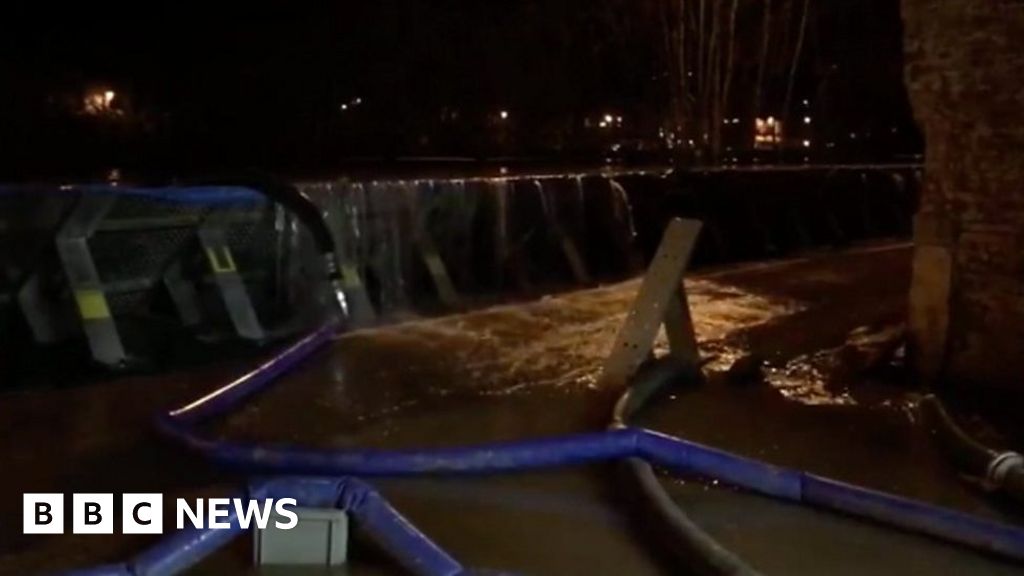 Flood water pours over the top of Bewdley's barriers