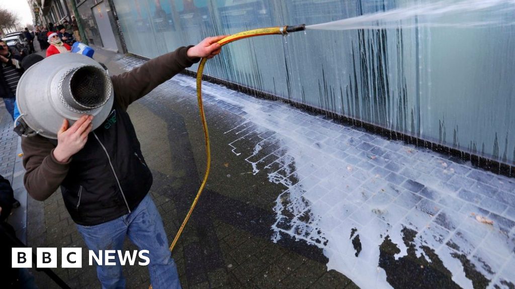 Protesting farmers spray milk in Brussels - BBC News