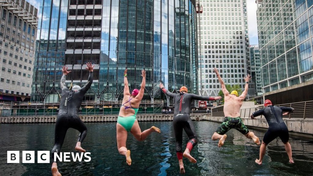 Open water swimming returns to Canary Wharf - BBC News